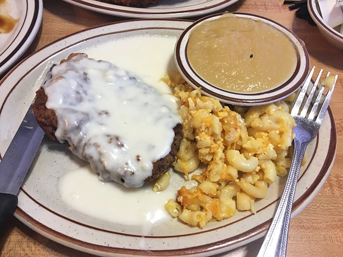 Country fried steak smothered in creamy gravy alongside golden hash browns—comfort food that hugs your soul before it fills your stomach.