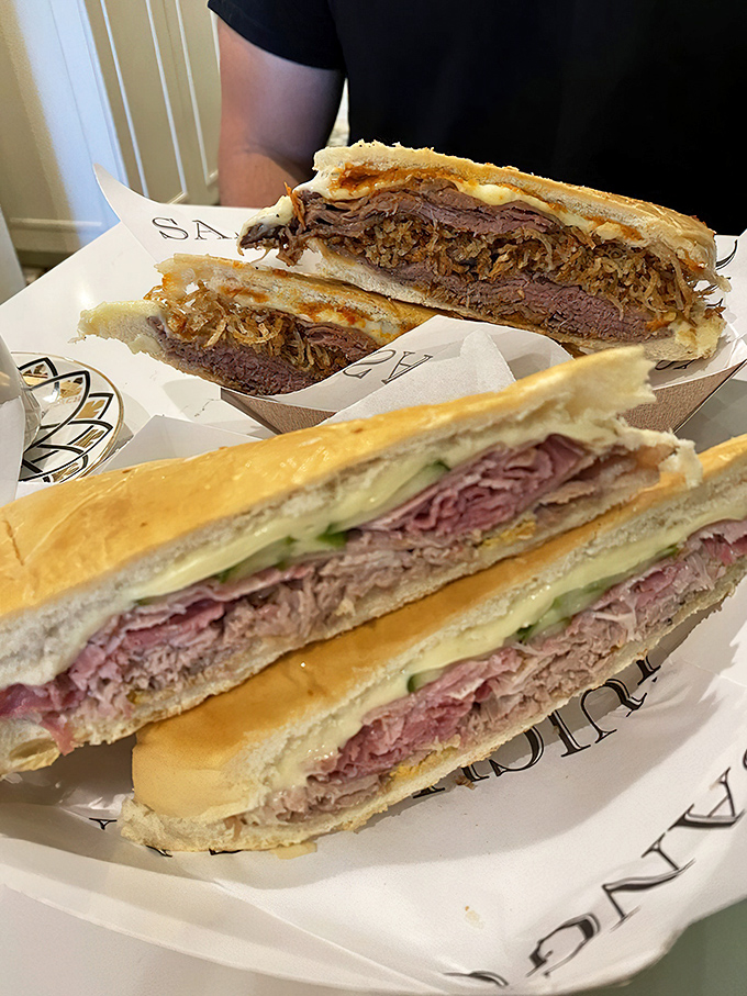 Behold the cross-section of perfection – layers of meat, cheese, and pickles pressed between bread that's achieved crispy-outside, soft-inside harmony.