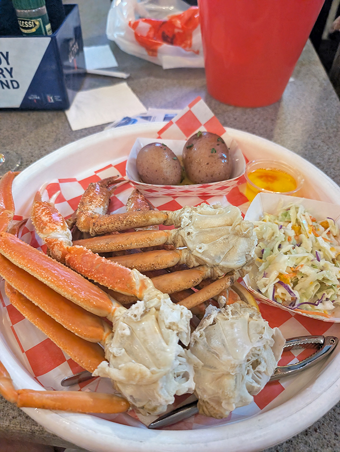 Snow crab legs arranged like a seafood crown, complete with royal accompaniments. The red-checkered paper says casual, but the presentation whispers "seafood royalty."