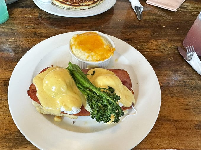 Eggs Benedict with a side of cheesy grits—proof that sometimes the best relationships are the ones you never expected to work so beautifully together.