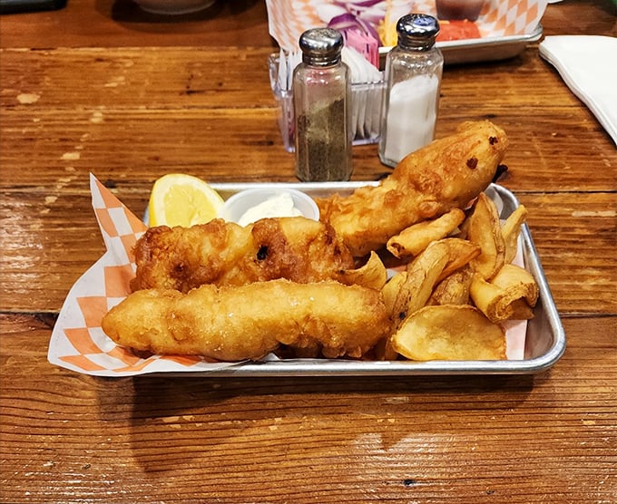 Fish and chips served on a metal tray—because some traditions are too perfect to mess with. That tartar sauce is calling your name.