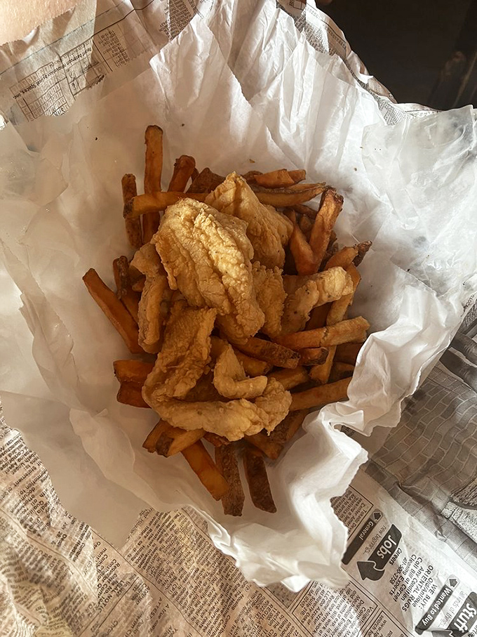 Even wrapped in newspaper, these fish and chips maintain their dignity—crispy, golden, and ready for their close-up before their inevitable demise.