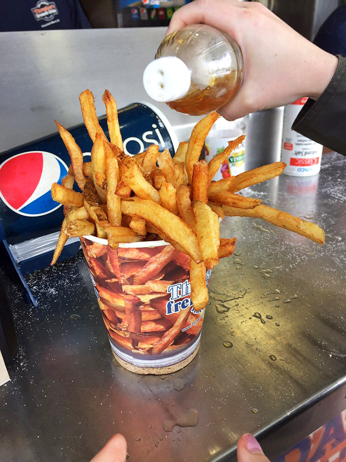 The sacred vinegar ritual—a tangy baptism that transforms mere fries into a religious experience. Ketchup believers, prepare for conversion.