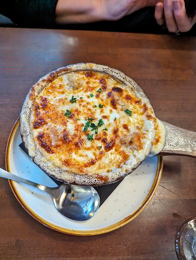 This isn't just French onion soup—it's a bubbling cauldron of comfort topped with a golden crown of melted cheese.
