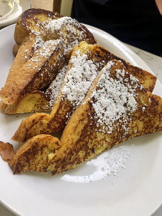 French toast so golden and fluffy, it practically glows with breakfast perfection – powdered sugar snow never looked so delicious.