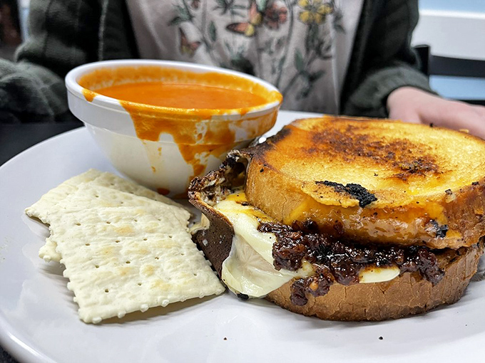 This isn't just a grilled cheese; it's comfort transformed into a masterpiece of melty goodness, accompanied by crackers and soup for dunking adventures.