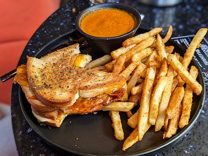 The legendary grilled cheese in its natural habitat—perfectly bronzed bread giving way to molten cheese, with a side cup of tomato soup for essential dunking operations.