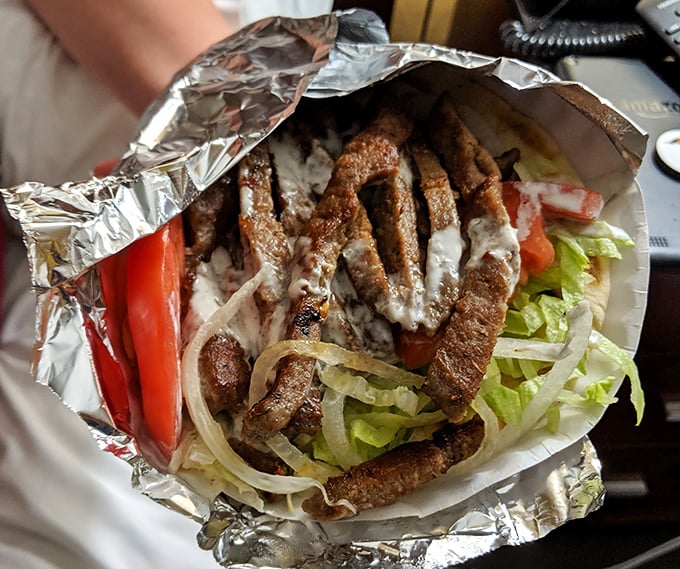 A perfect gyro wrapped in foil like a savory present—juicy meat, fresh veggies, and sauce that makes you forget you came for chicken.