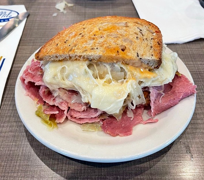 The half Reuben reveals its secrets – layers of tender corned beef, tangy sauerkraut, and melted Swiss cheese creating the holy trinity of sandwich perfection.