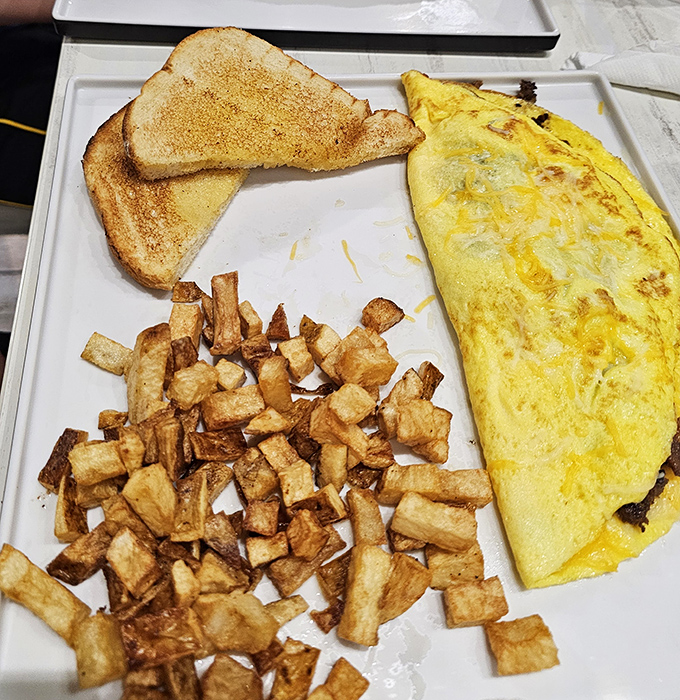 This isn't just breakfast—it's edible geometry: golden triangle toast, perfectly squared home fries, and a folded omelet that defies gravity.