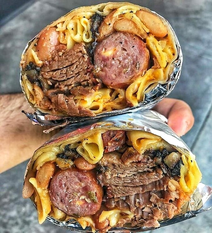 This burrito cross-section reveals the architectural genius behind La Banqueta's creations. Multiple meats, beans, and noodles coexisting in perfect harmony – if only world peace were this achievable.