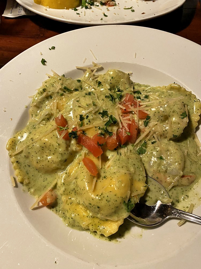 These ravioli aren't just swimming in pesto—they're doing the backstroke in a pool of herby, creamy indulgence that demands to be sopped up.