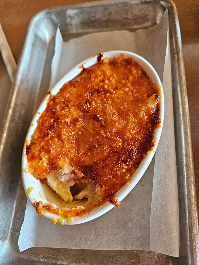 This isn't just mac and cheese; it's a religious experience in an oval dish. The burnished top gives way to creamy pasta beneath – worth every minute of the wait.