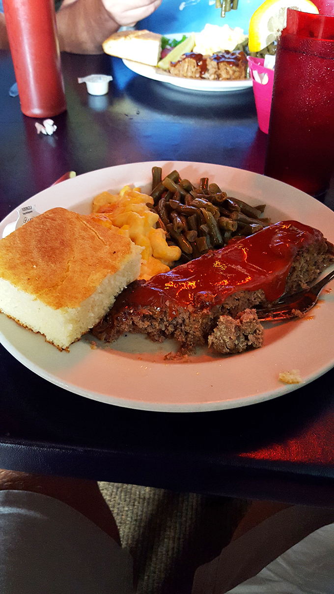The meatloaf arrives with its red sauce crown, flanked by mac and cheese and green beans—a royal feast at commoner prices.