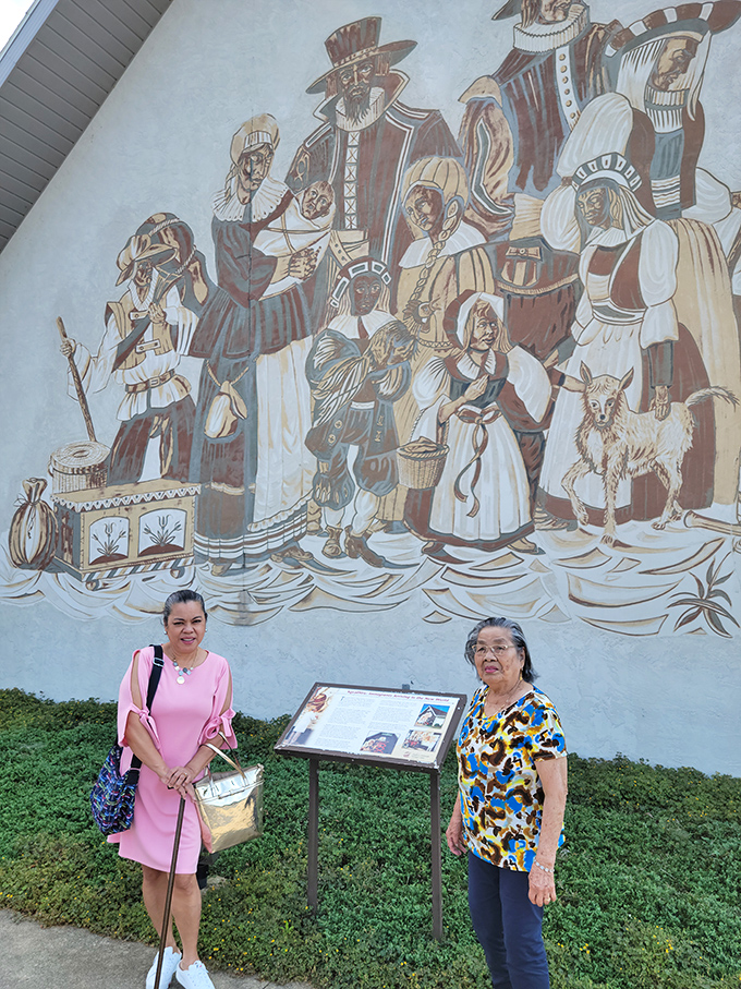 A colorful mural depicting historical scenes provides context for visitors learning about the immigration journey of the area's early settlers.