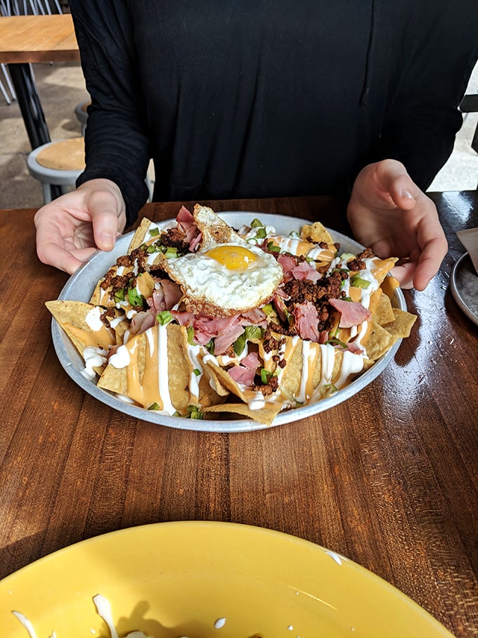 Breakfast meets happy hour with this nacho masterpiece topped with a sunny-side-up egg – the hangover cure you never knew you needed.