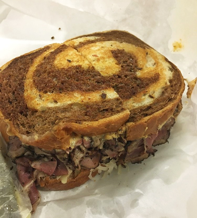 The marbled rye creates the perfect canvas for this work of art—a sandwich that demands both hands and your complete attention.