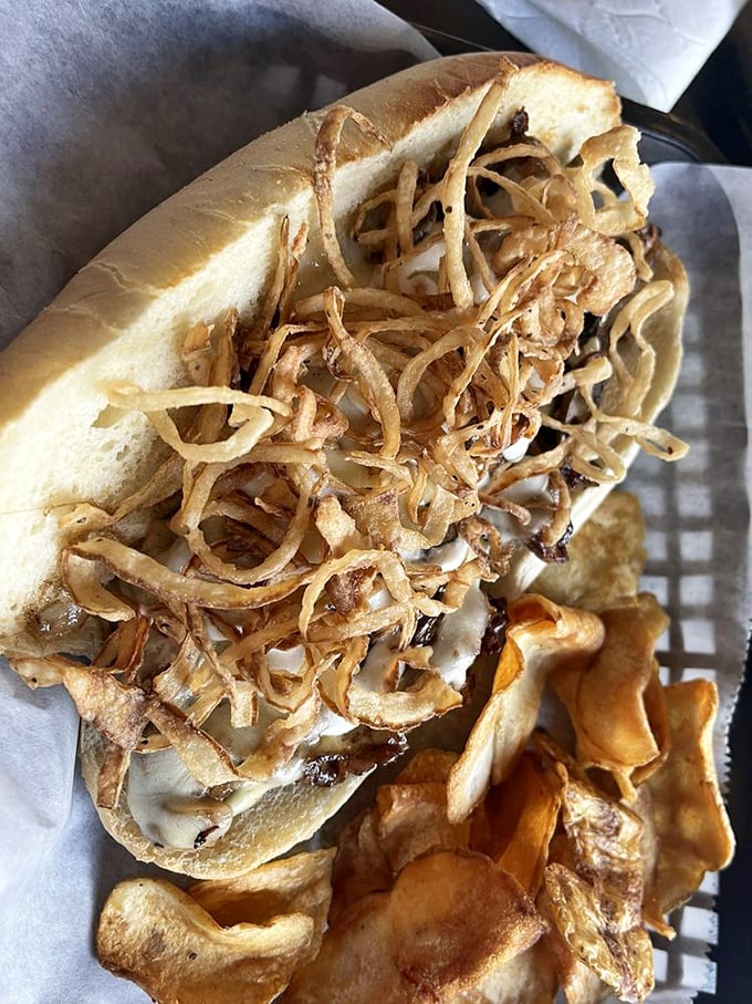 Not your average sandwich jailbreak—this creation piles crispy onion straws high enough to require a permit from the FAA.