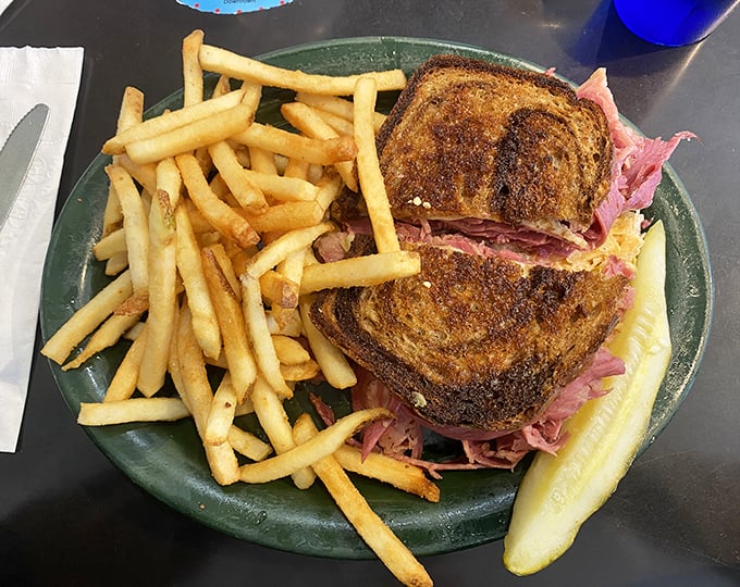 A proper Reuben demands proper accompaniment. Sam's delivers with crispy fries and a pickle that snaps like a comeback in a 1940s screwball comedy.
