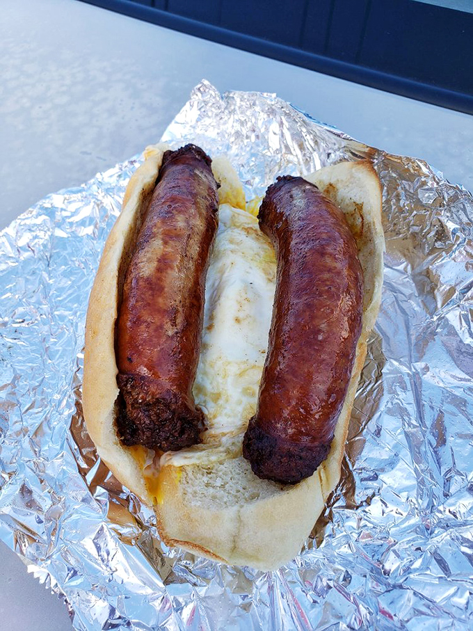 Two plump sausages nestled in a soft roll with an egg between them—a breakfast sandwich that makes hitting the snooze button a criminal offense.