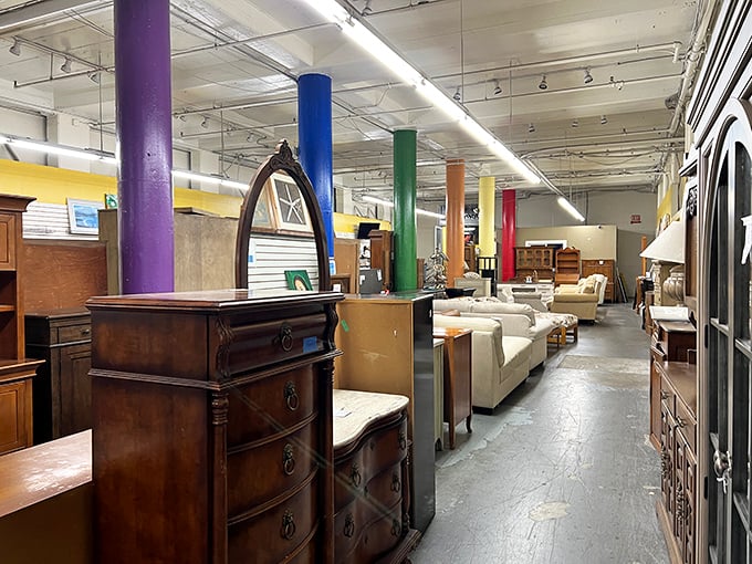 Colorful support pillars guide shoppers through a furniture wonderland where mid-century treasures mingle with contemporary finds, all waiting for new homes.