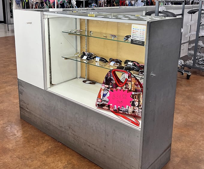 Behind glass lies affordable glamour. This accessories display case holds sunglasses and handbags waiting for their second chance at fashionable life.