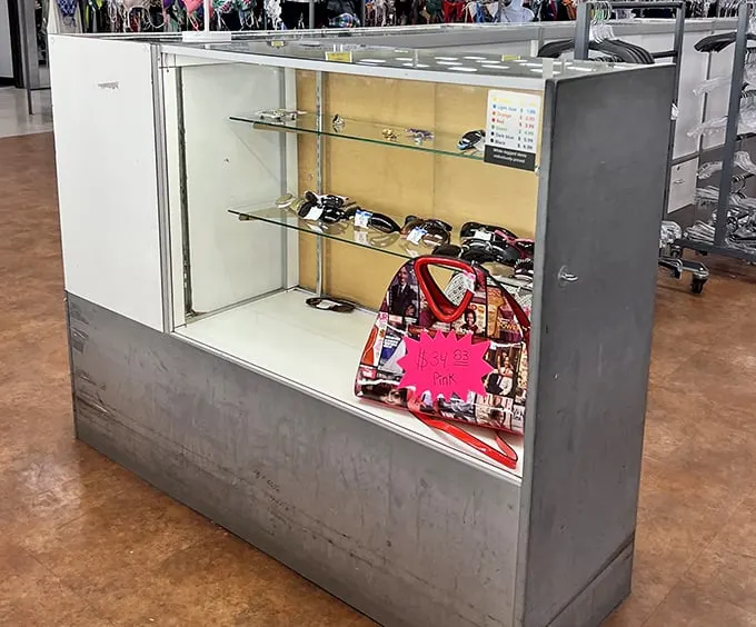 Behind glass lies affordable glamour. This accessories display case holds sunglasses and handbags waiting for their second chance at fashionable life.