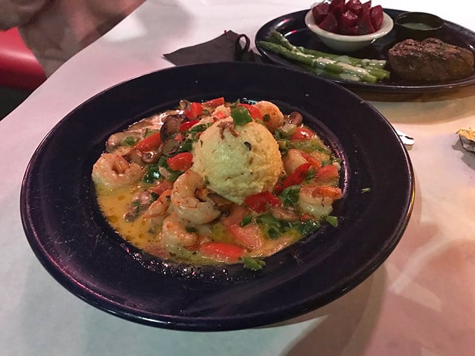 Shrimp and grits elevated to an art form—plump shellfish swimming in savory broth around a golden cornmeal island. Southern comfort with coastal sophistication.