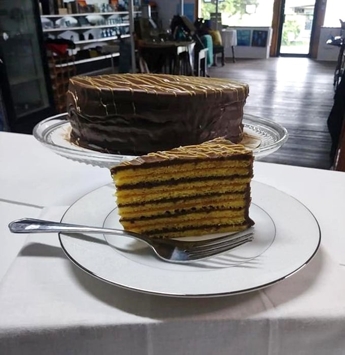 The cross-section tells the story – eight impossibly thin layers of golden cake, each separated by chocolate frosting. Engineering marvel meets comfort food.