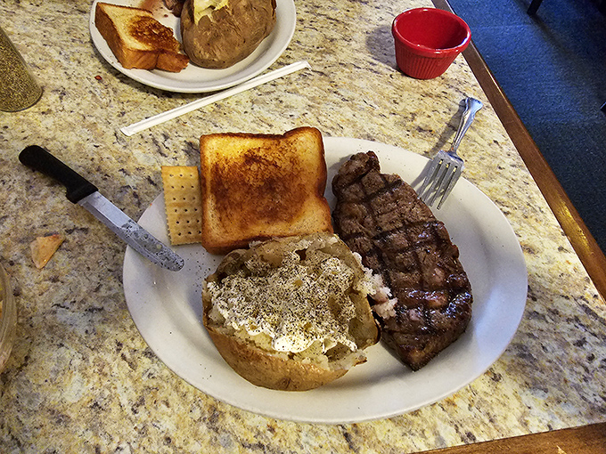Steak and a loaded potato – the classic American dinner that never disappoints. Those grill marks aren't just for show; they're flavor signatures.
