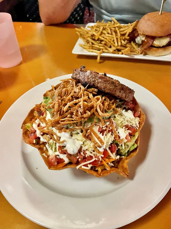 A taco salad that deserves its own area code. That crispy shell cradles a mountain of goodness topped with what appears to be a Beyond patty.