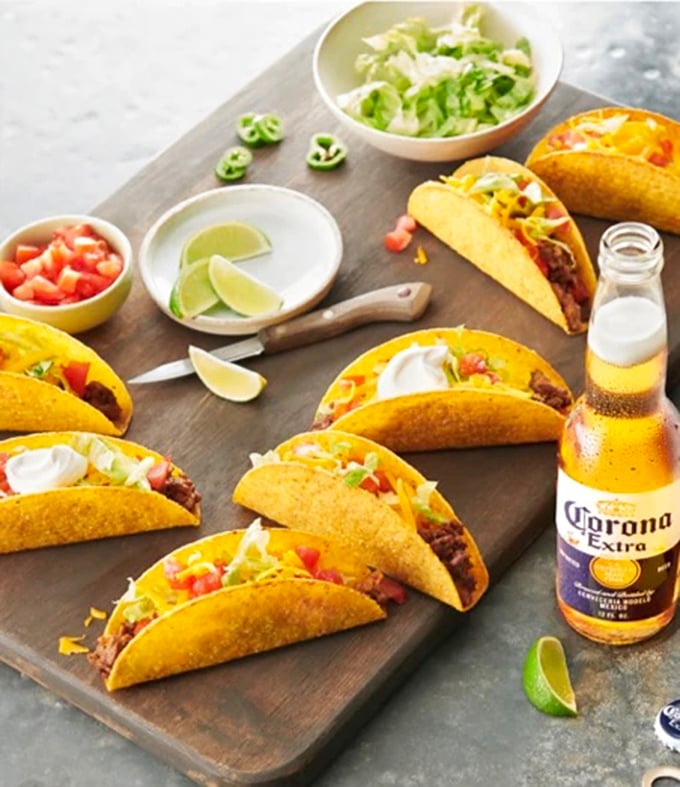 Tacos lined up like eager contestants in a beauty pageant, each one dressed to impress with fresh toppings and a Corona standing by for moral support.