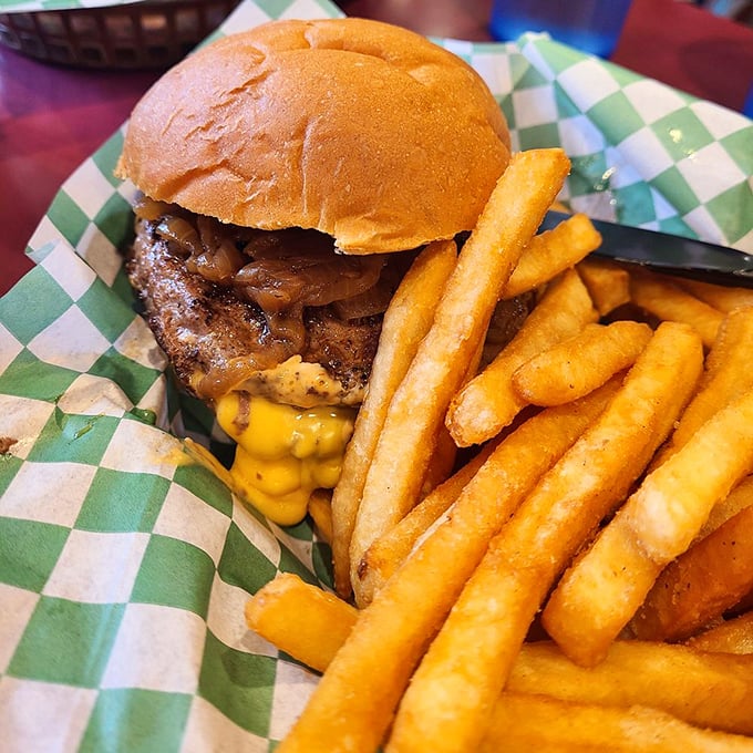The classic Juicy Lucy in its natural habitat, surrounded by golden fries. That cheese isn't just melted—it's plotting a delicious escape.