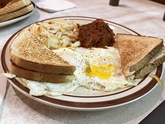 The classic two-eggs breakfast with hash browns and toast—proof that sometimes the simplest combinations create the most profound satisfaction.