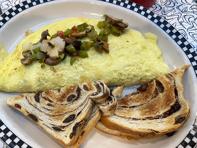 Breakfast doesn't get more photogenic than this—a fluffy omelet stuffed with veggies alongside marble rye toast that's practically begging to be devoured.