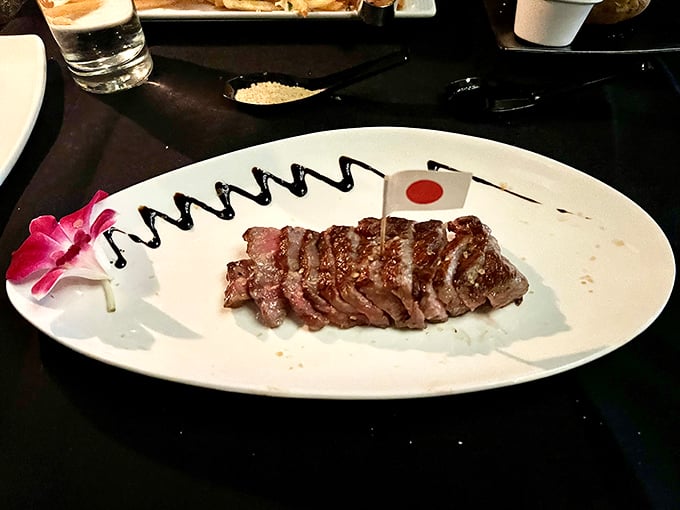 Wagyu beef sliced with surgical precision, complete with a tiny Japanese flag. It's like meat origami—an art form that happens to be delicious.