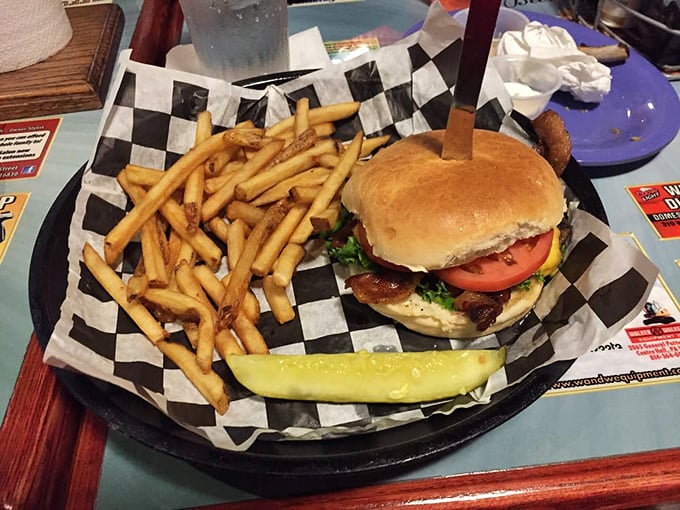 This isn't just a burger and fries—it's comfort on a checkered paper, with that pickle spear standing guard like it knows something special is happening.