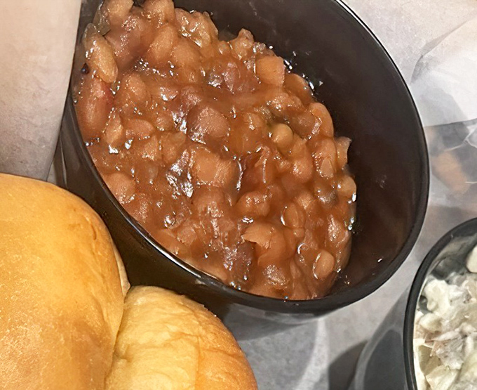 These baked beans aren't just a side dish—they're a sweet, savory symphony that's been simmering its way to perfection alongside that golden roll.