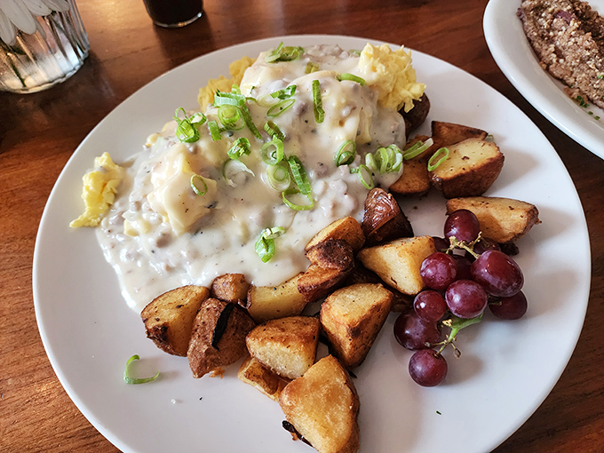 Biscuits and gravy that would make your grandmother simultaneously proud and jealous. Those potatoes and grapes aren't just garnish—they're supporting actors deserving awards.