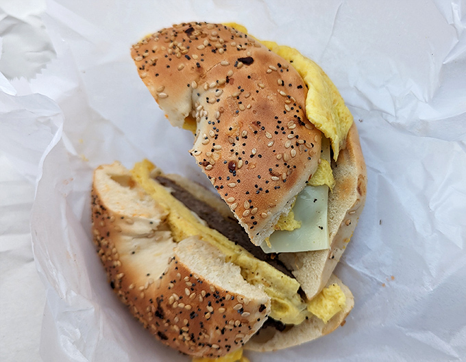 Breakfast sandwich nirvana on a seeded bagel – eggs, meat, and cheese coming together like the world's most delicious morning rock band.