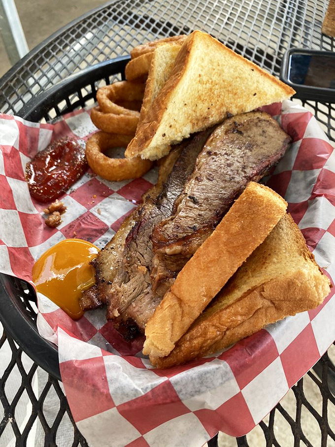 This brisket sandwich isn't just a meal—it's a commitment. That smoke ring tells you everything you need to know about their barbecue philosophy.
