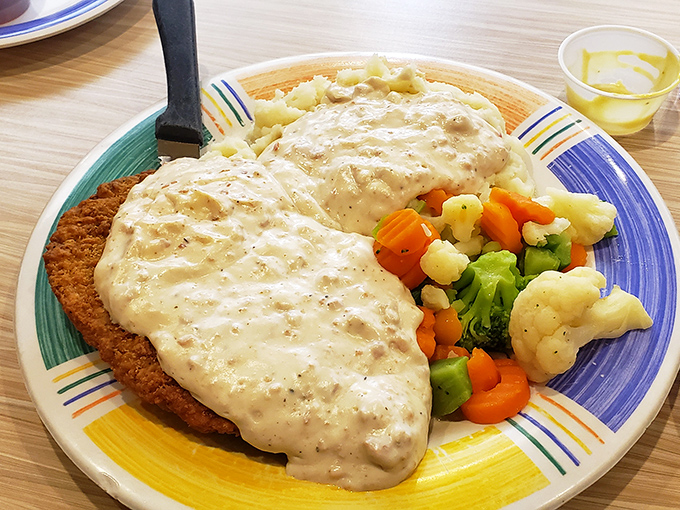 This isn't just dinner—it's edible therapy. Crispy chicken fried steak smothered in pepper gravy with a vegetable medley that counts as "eating healthy."