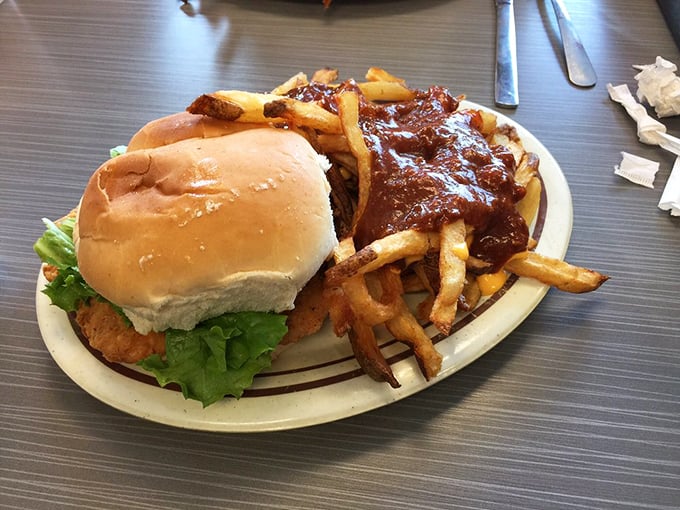 The ultimate power couple: a perfectly crafted chicken sandwich alongside fries swimming in that legendary homemade chili.