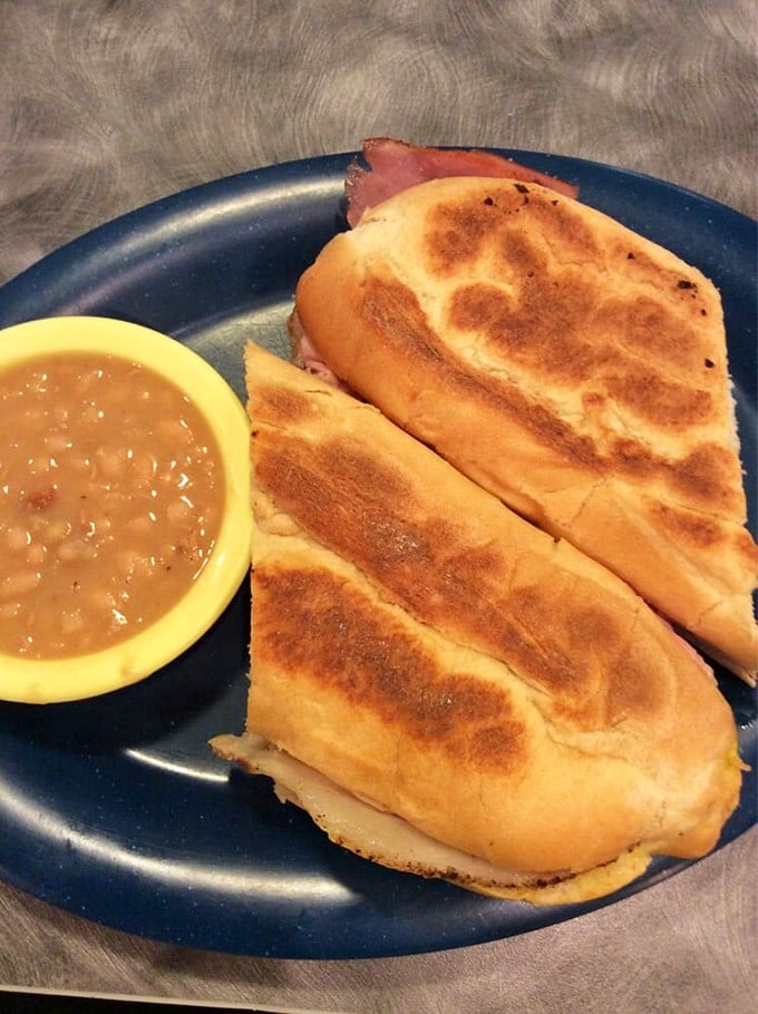 A proper Cuban sandwich should require both napkins and commitment—this golden-pressed beauty delivers with ham, pork, and just the right balance of mustard tang.