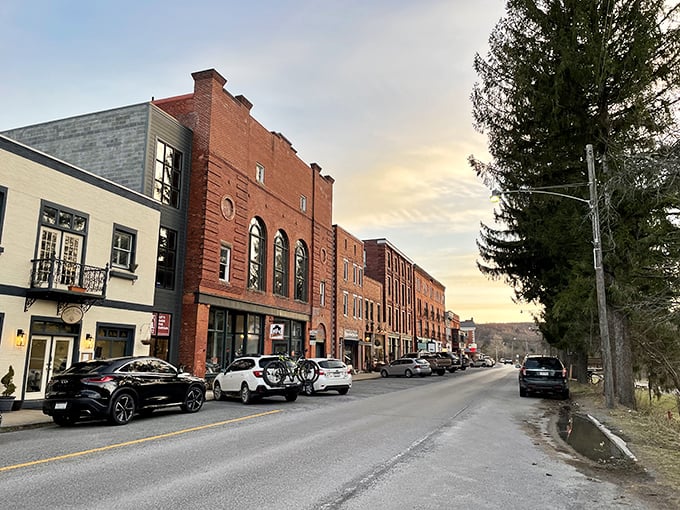 Thomas's downtown at dusk captures that magical moment when the streetlights come on and the brick buildings glow with warmth against the mountain backdrop.