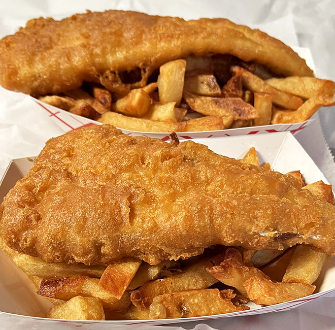 Two golden treasures nestled in paper boats—the kind of fish and chips that make you question why you've wasted time on lesser versions.