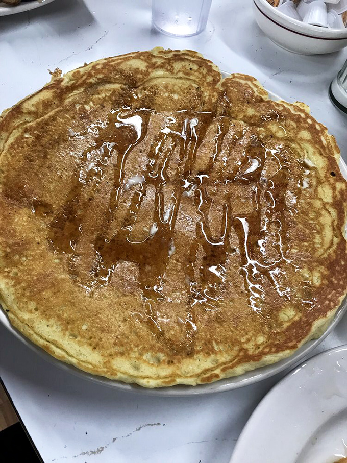 This isn't just a pancake—it's a commitment. When your breakfast hangs over the edge of the plate, you know you're in for a serious morning relationship.