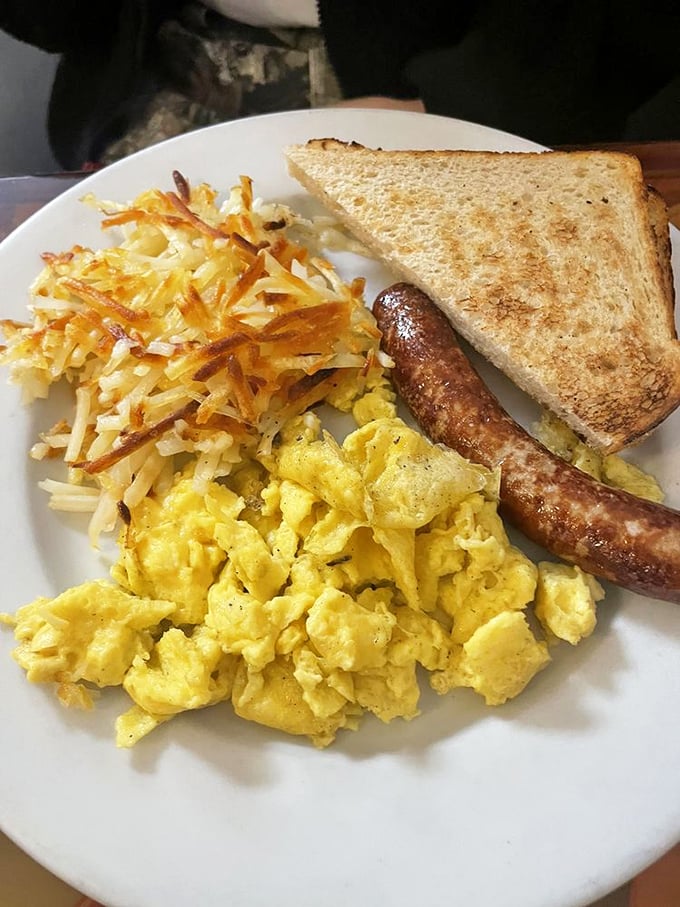 The breakfast trifecta: scrambled eggs with that perfect just-set texture, hash browns with the ideal crisp-to-tender ratio, and sausage that demands your immediate attention.