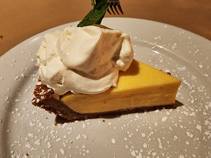 The key lime pie arrives like a ray of sunshine—bright, tangy, and topped with a cloud of whipped cream that defies gravity.