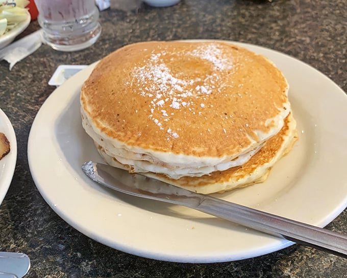 Behold the tower of power—three perfectly stacked pancakes that could double as frisbees. Your diet doesn't stand a chance.